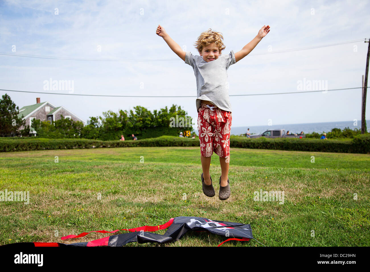 Boy jumping mid air in field Stock Photo - Alamy