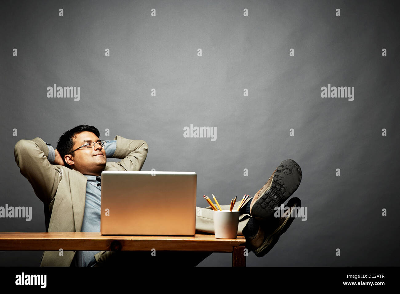 Man relaxing with feet up on table Stock Photo - Alamy
