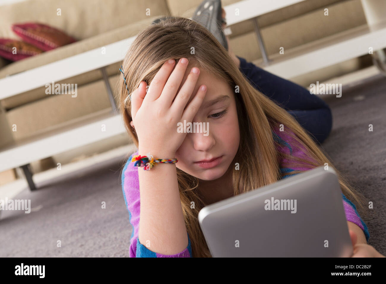 Girl looking at digital tablet in puzzlement Stock Photo - Alamy
