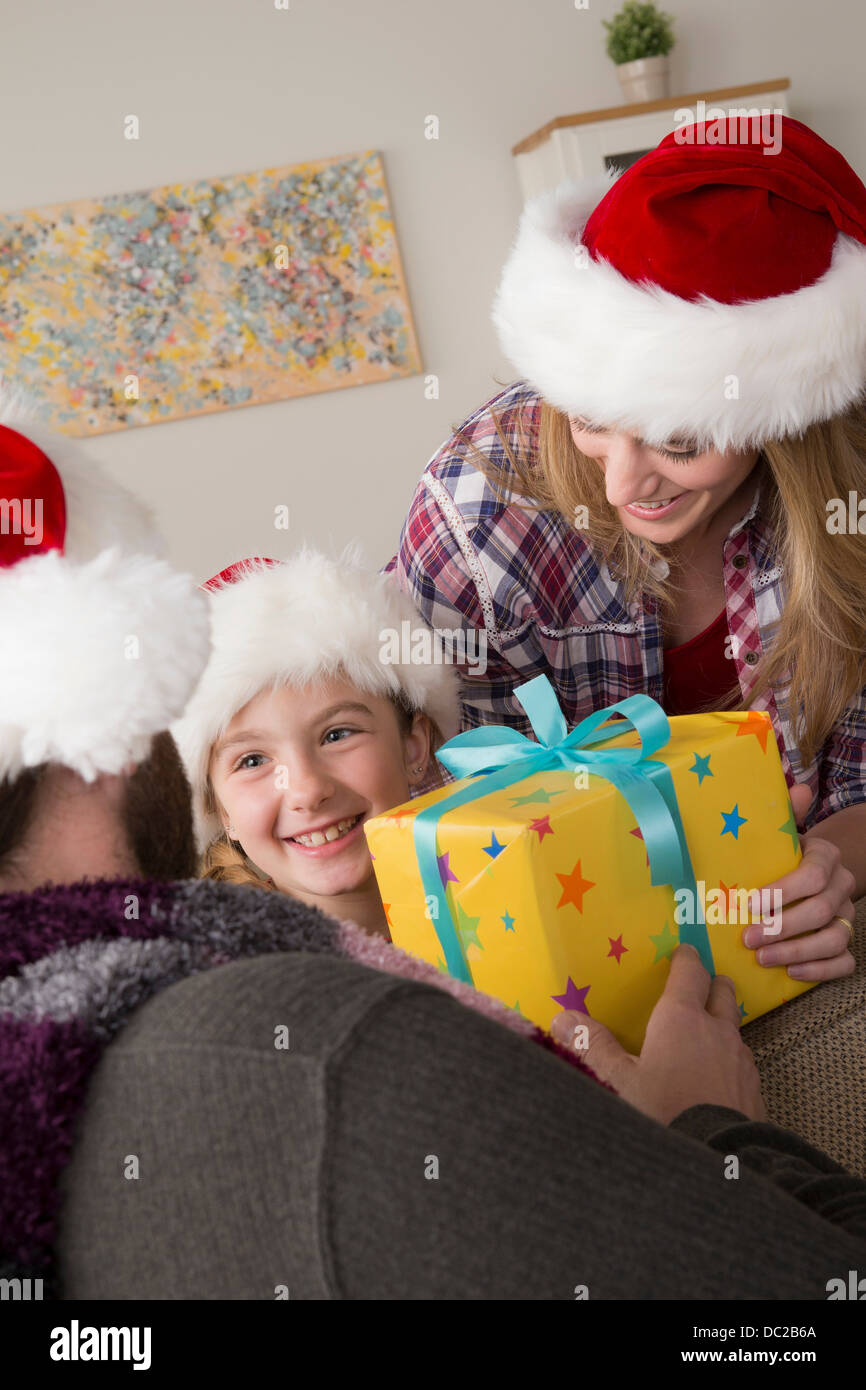 Parents giving child christmas gift Stock Photo - Alamy