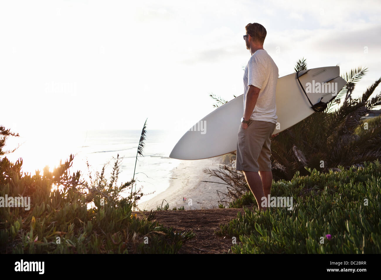 Surfer looking at ocean Stock Photo - Alamy