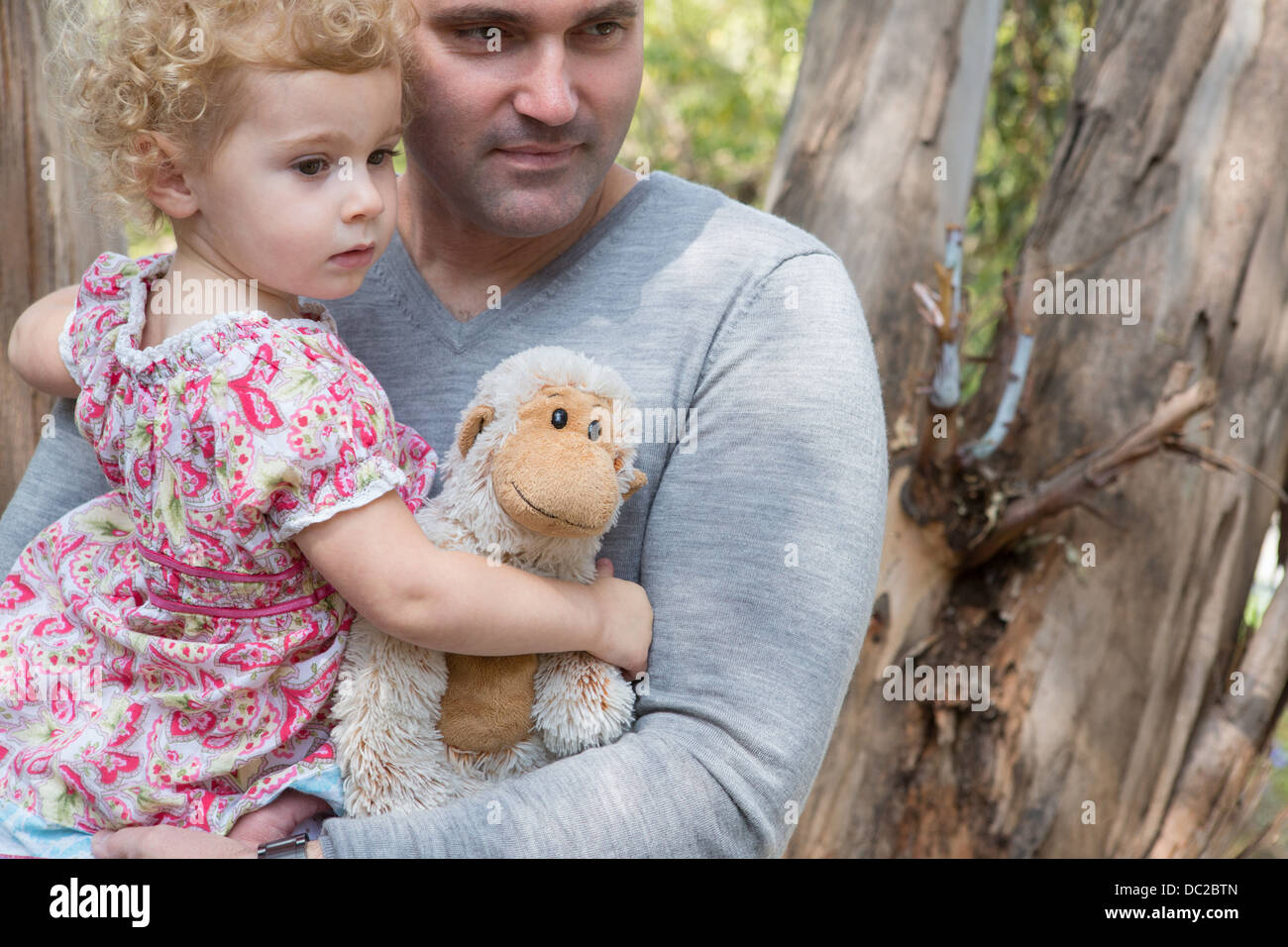 Father carrying child with soft toy Stock Photo - Alamy