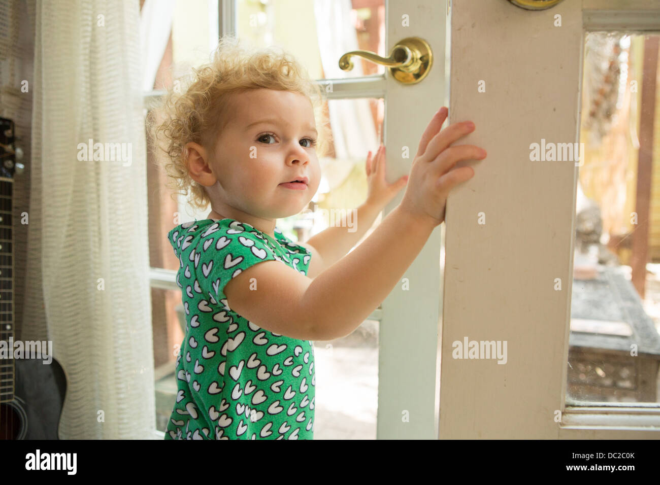 Toddler opening door Stock Photo - Alamy