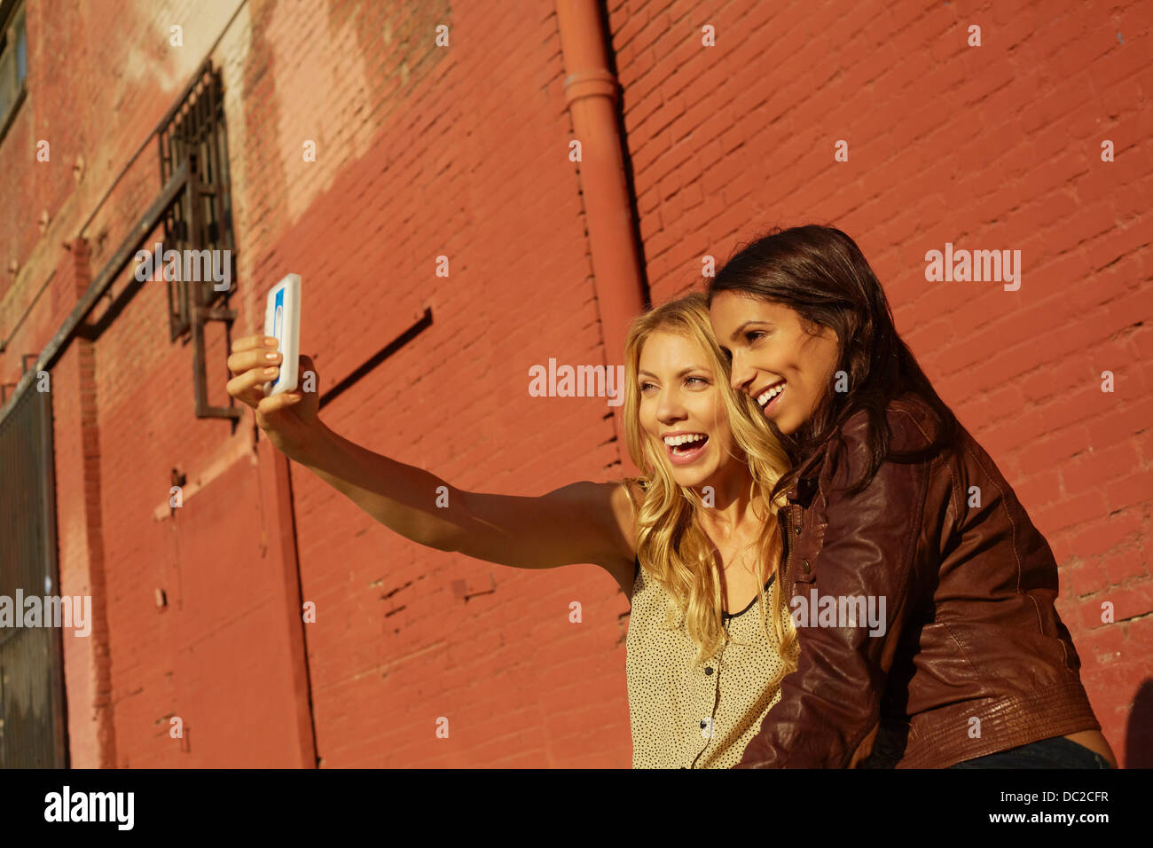 Red wall two women phone hi-res stock photography and images - Alamy