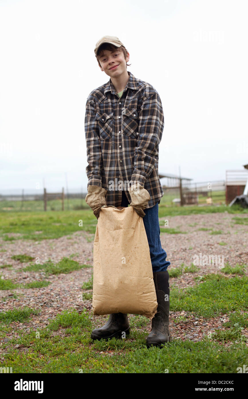Boy carrying sack of feed Stock Photo - Alamy