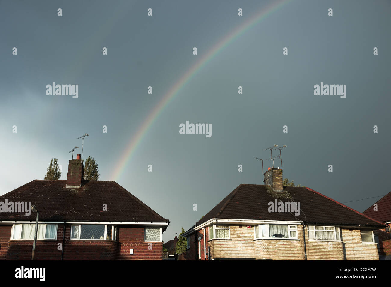 Rainbow over houses Stock Photo - Alamy