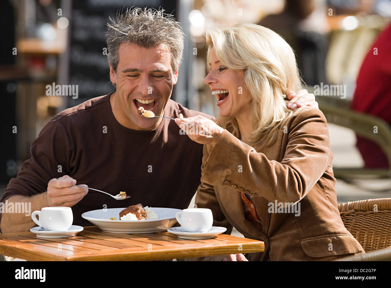 A woman feeding a man dessert Stock Photo - Alamy