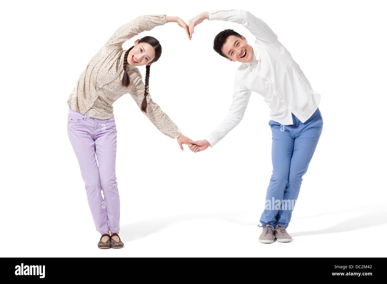 Retro couple making heart shape with their arms Stock Photo - Alamy