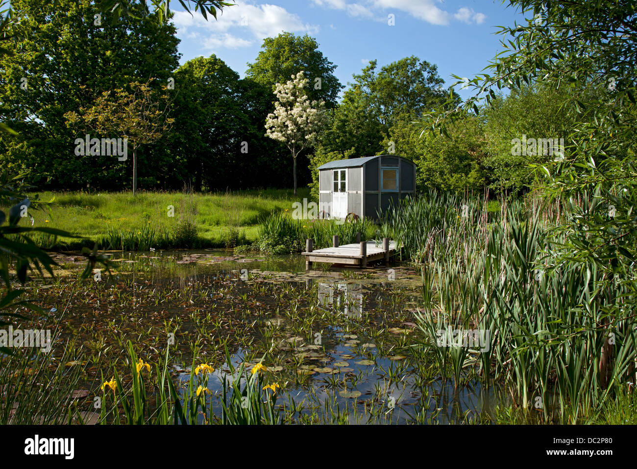 Shepherds Hut on wheels in garden by pond, England Stock Photo - Alamy
