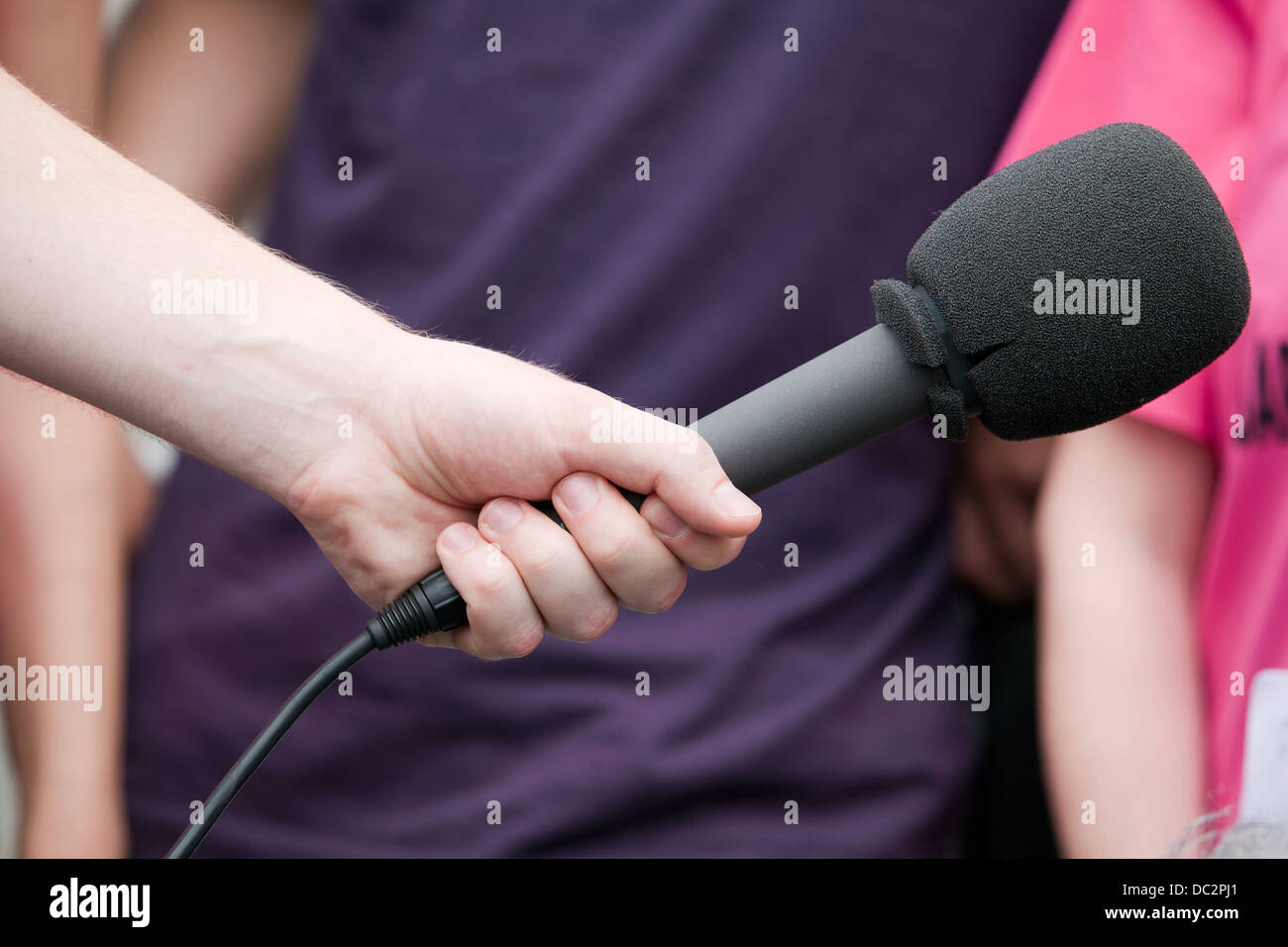 A journalist is making a interview with a microphone Stock Photo - Alamy