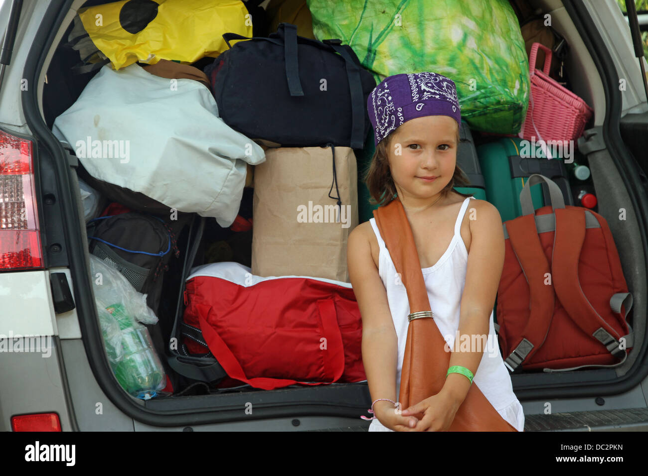 beautiful smiling girl with brown bag and suitcases in car Stock Photo ...