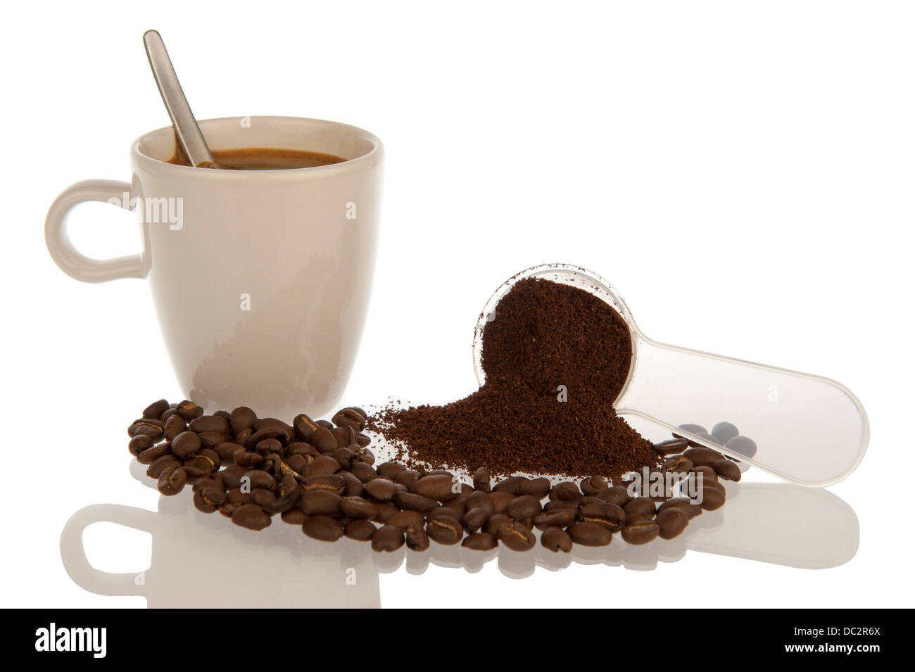 Coffee cup with beans and powder spoon arranged and isolated in a white ...