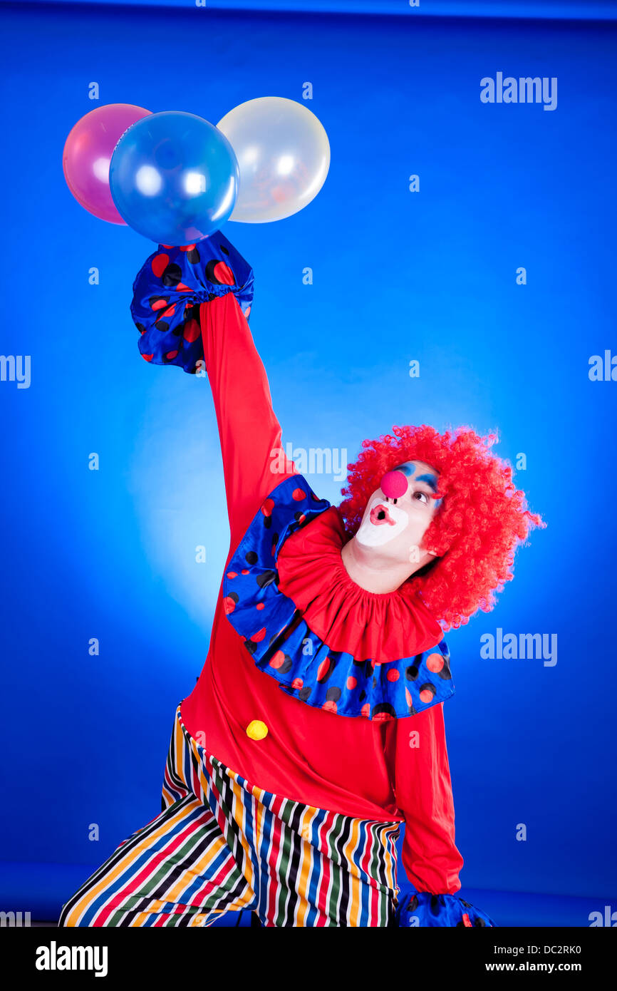 Clown on blue backgound studio inside shot Stock Photo - Alamy