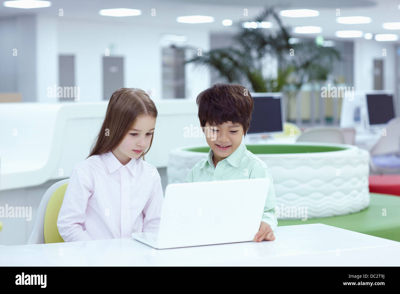 a girl and a boy using a laptop together Stock Photo - Alamy