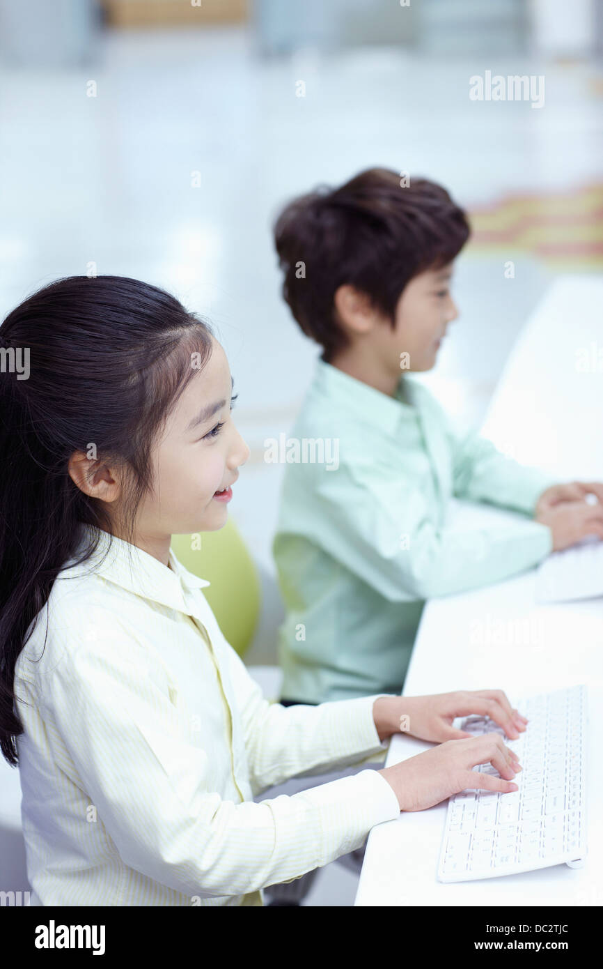 a boy and a girl using each PC Stock Photo - Alamy