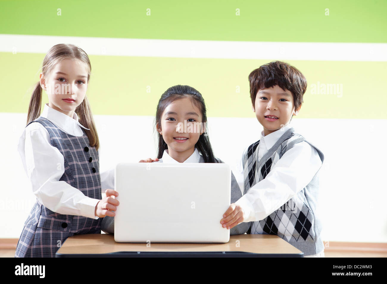 kids using a laptop together in a classroom Stock Photo - Alamy