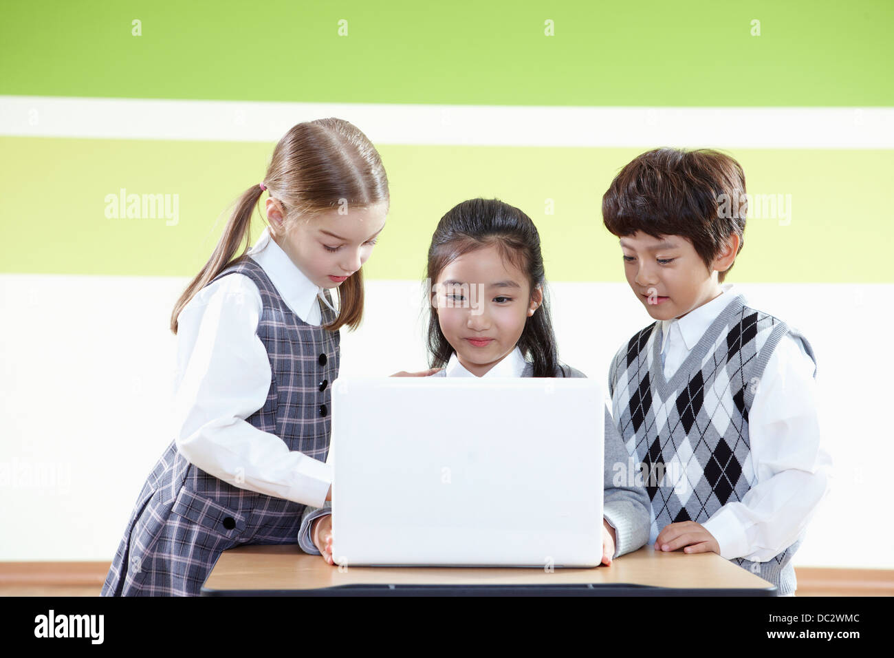 kids using a laptop together in a classroom Stock Photo - Alamy