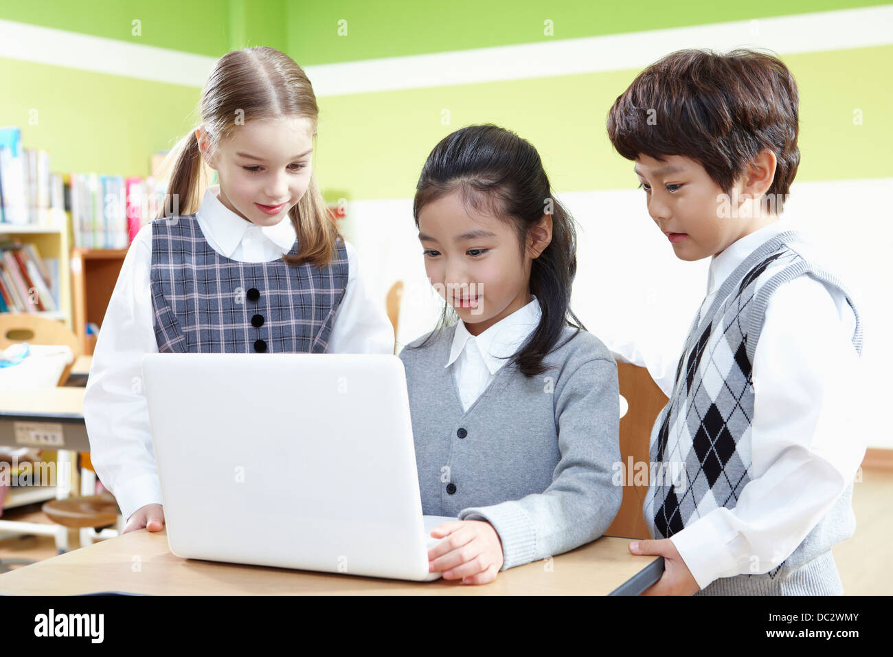 kids using a laptop together in a classroom Stock Photo - Alamy