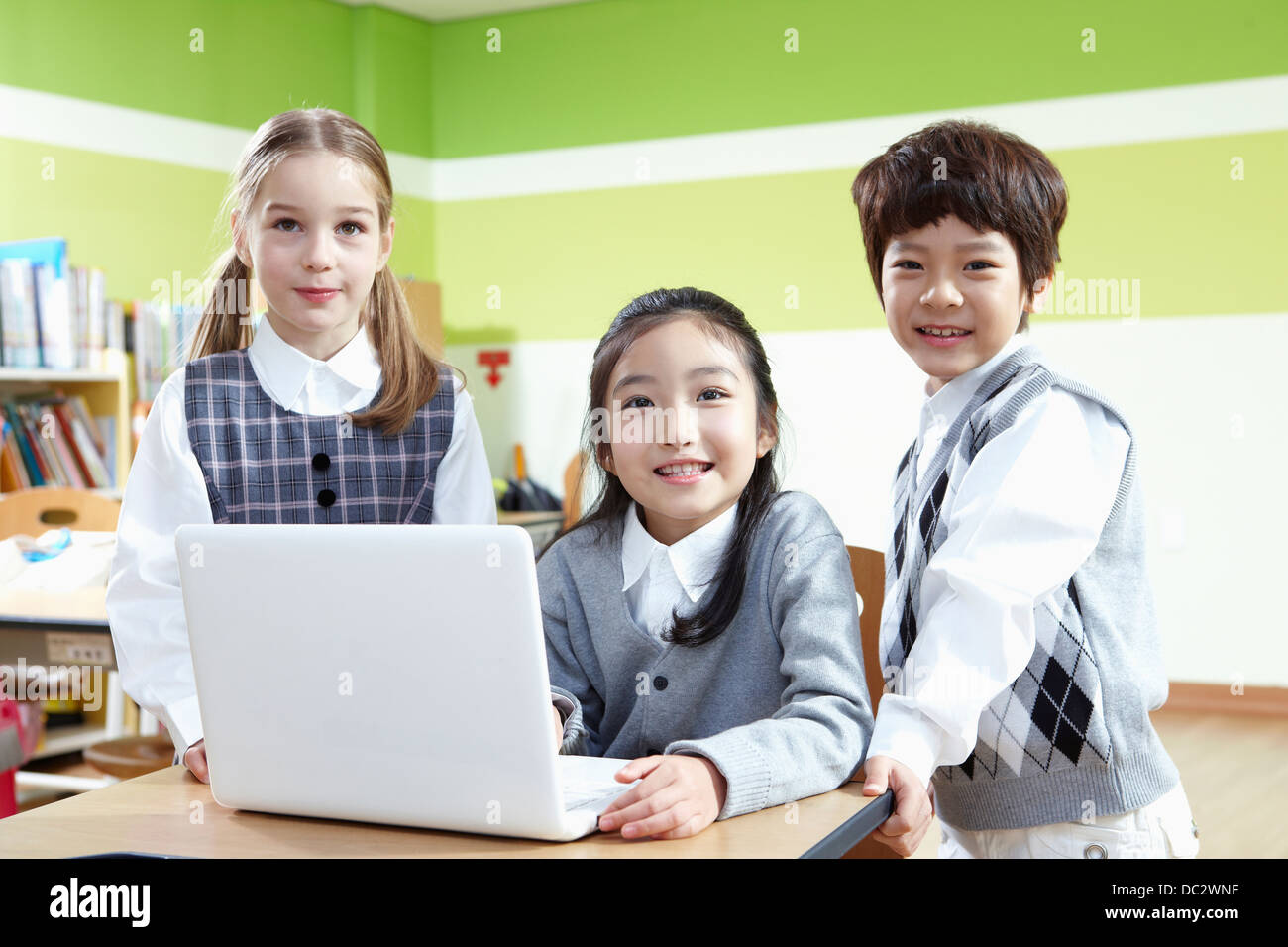 kids using a laptop together in a classroom Stock Photo - Alamy