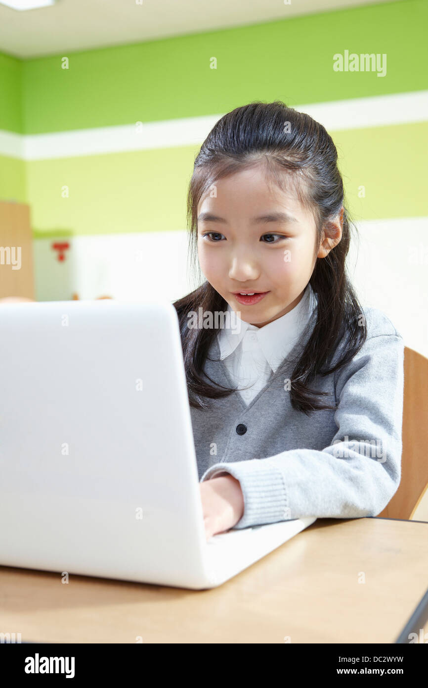 a girl using a laptop in a classroom Stock Photo - Alamy