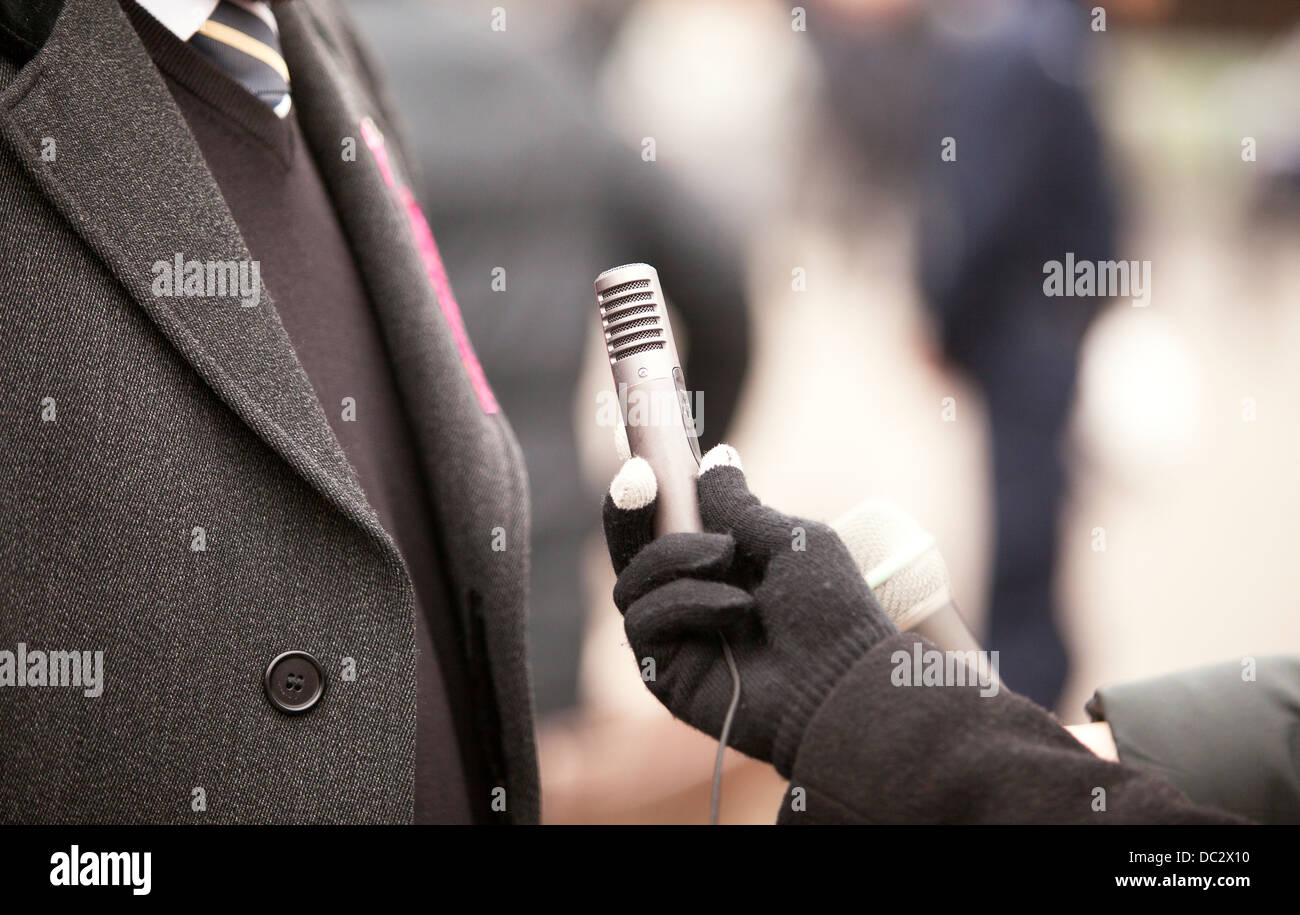 A journalist is making a interview with a microphone Stock Photo - Alamy