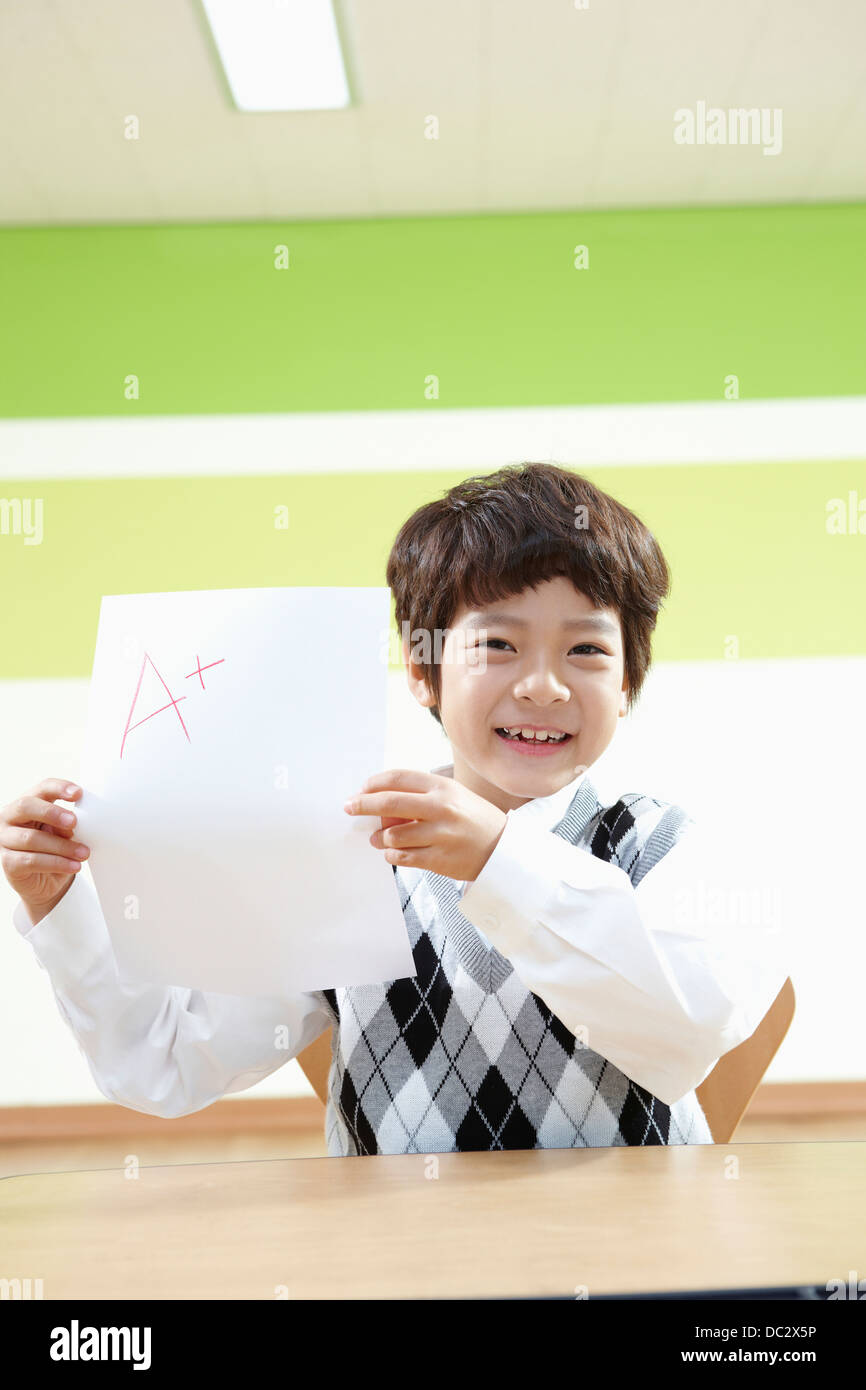 a boy with A+ mark on a paper Stock Photo - Alamy