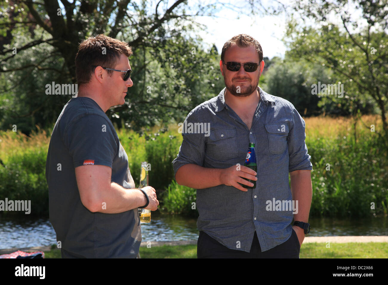 Men standing and drinking beer outside Stock Photo - Alamy