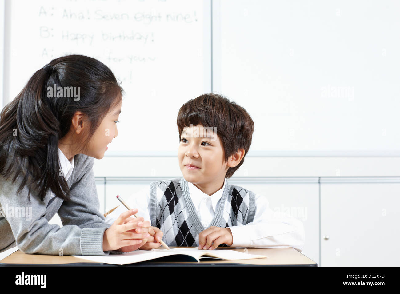 a girl helping a boy with studying Stock Photo - Alamy