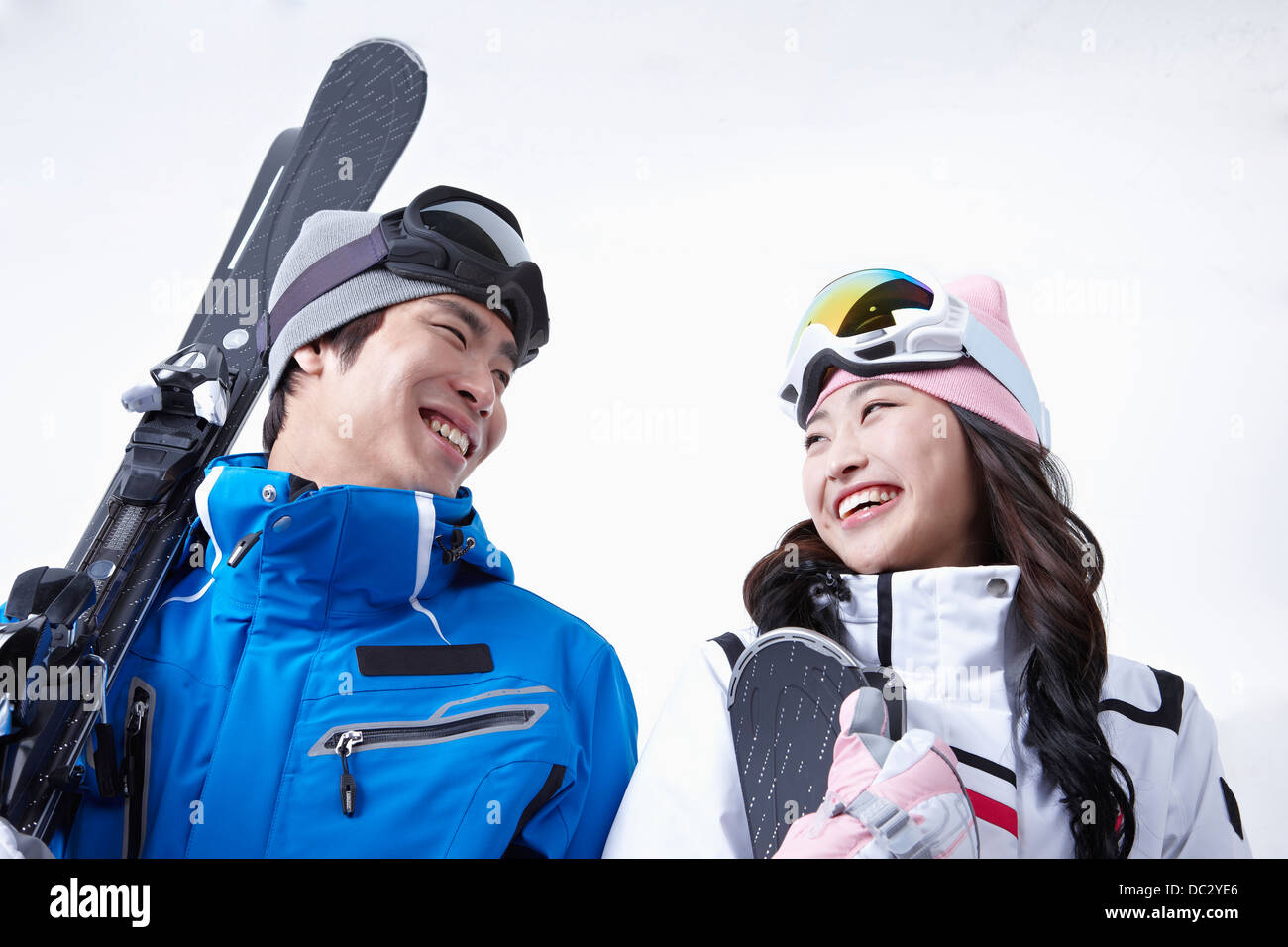 a couple in ski outfit posing in white background Stock Photo - Alamy