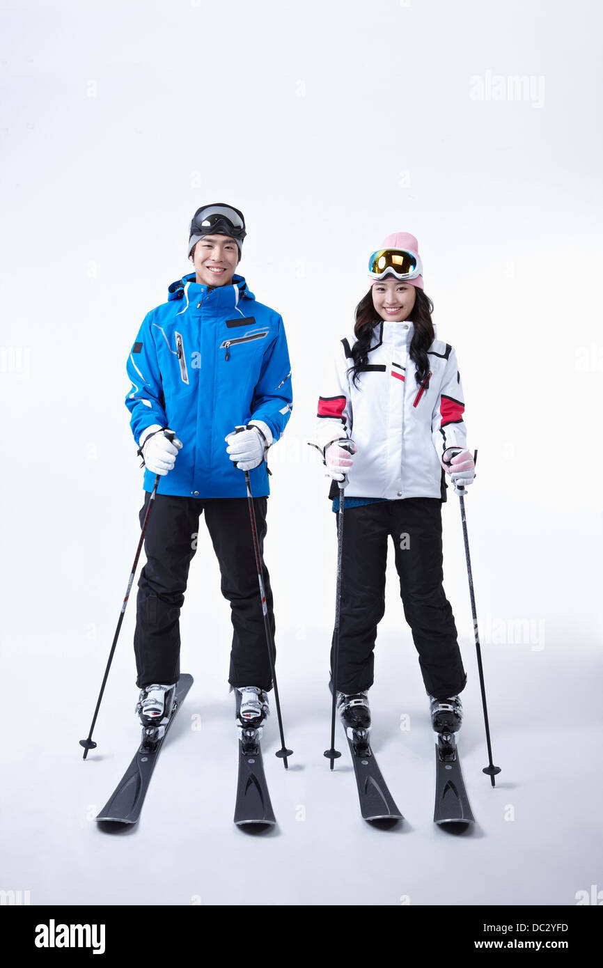 a couple in ski outfit posing in white background Stock Photo - Alamy