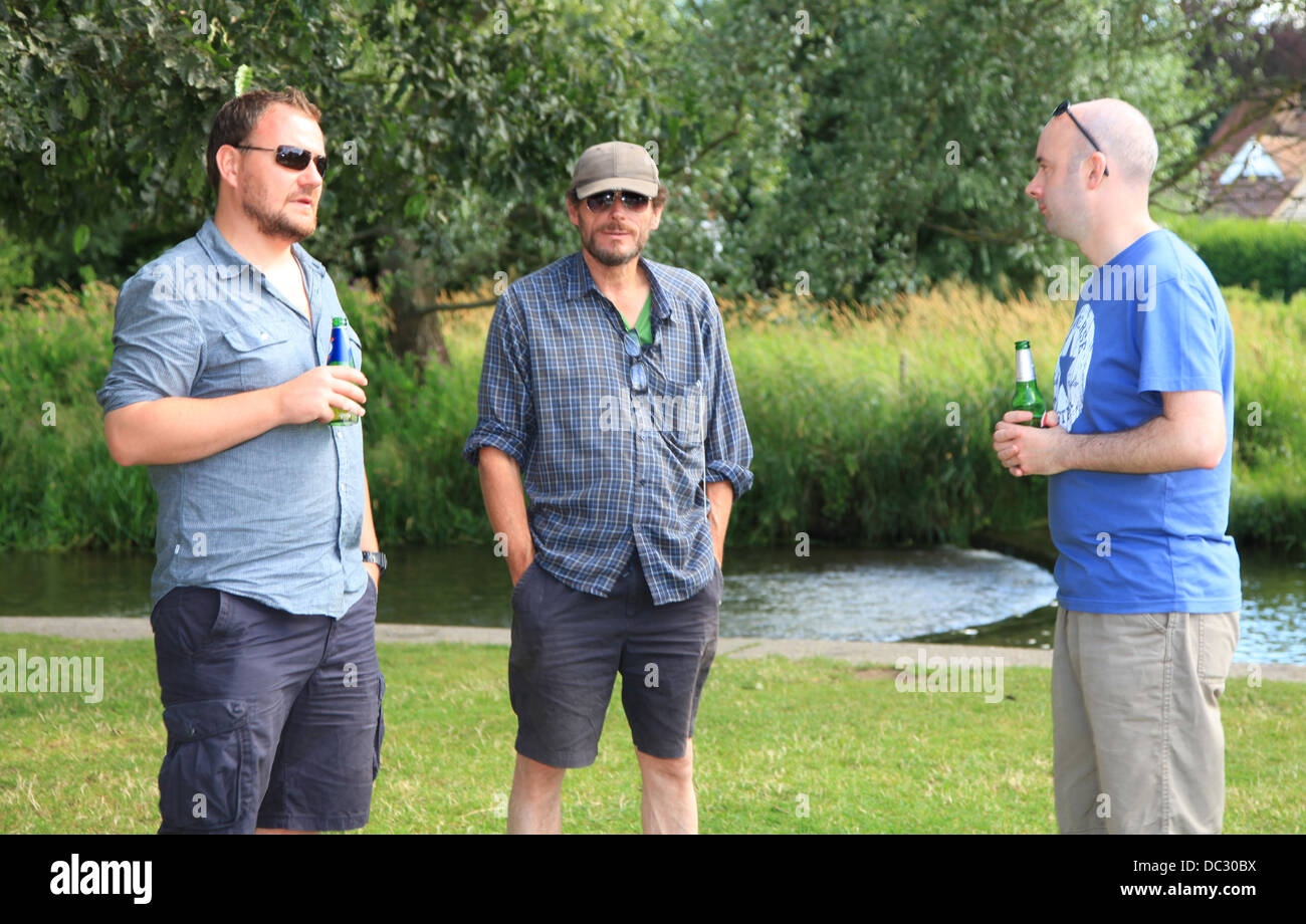 Men standing and drinking beer outside Stock Photo - Alamy