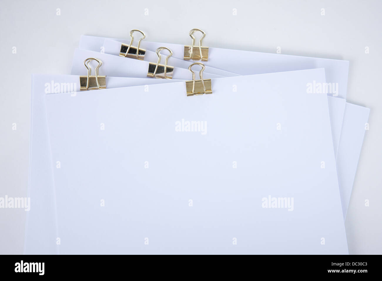 golden double clips on papers Stock Photo - Alamy
