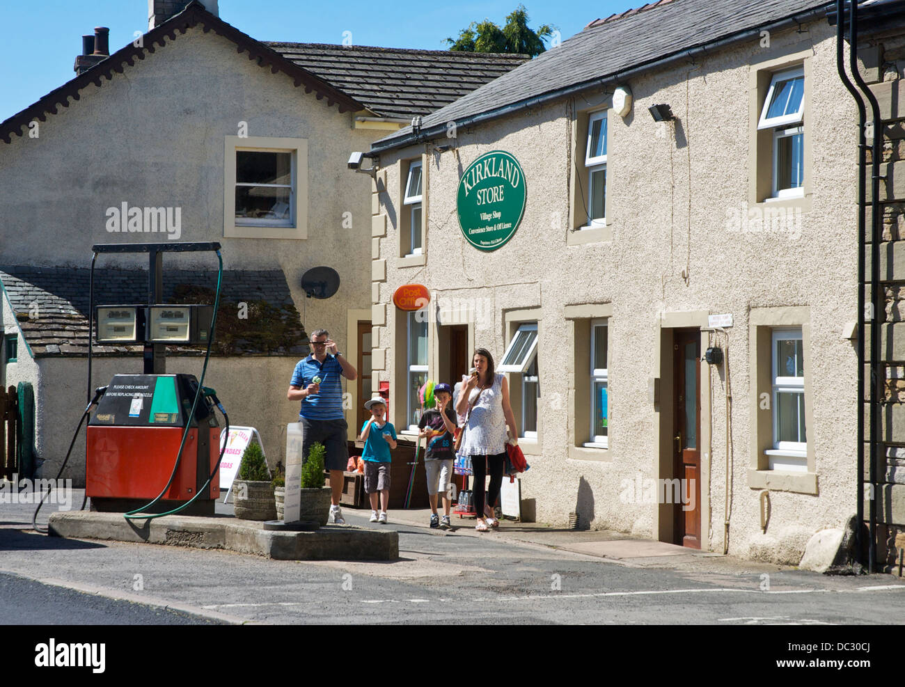 Family leaving Kirkland Store in the village of Caldbeck, Lake District ...