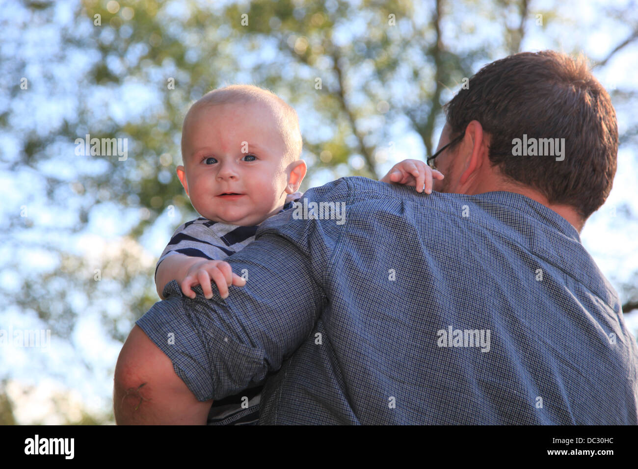 Baby looking over the shoulder of his dad Stock Photo - Alamy