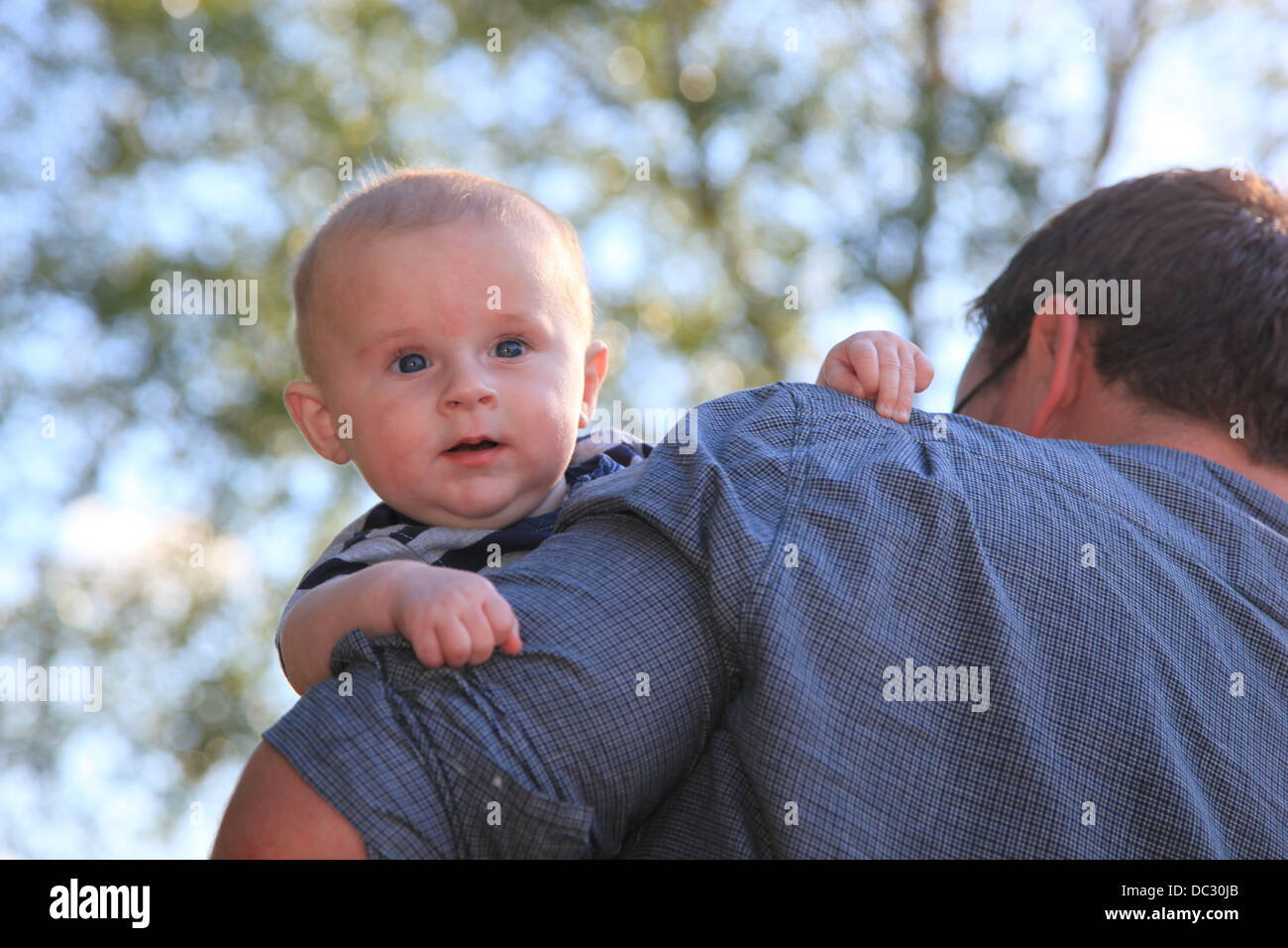 Baby looking over the shoulder of his dad Stock Photo - Alamy