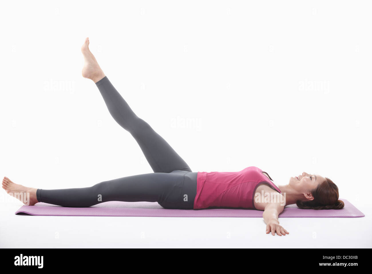 a woman doing yoga on a mat Stock Photo - Alamy