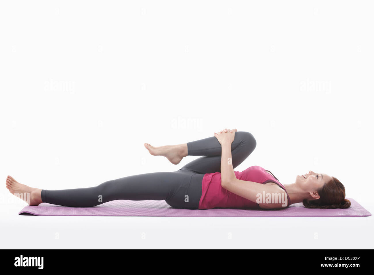 a woman doing yoga on a mat Stock Photo - Alamy