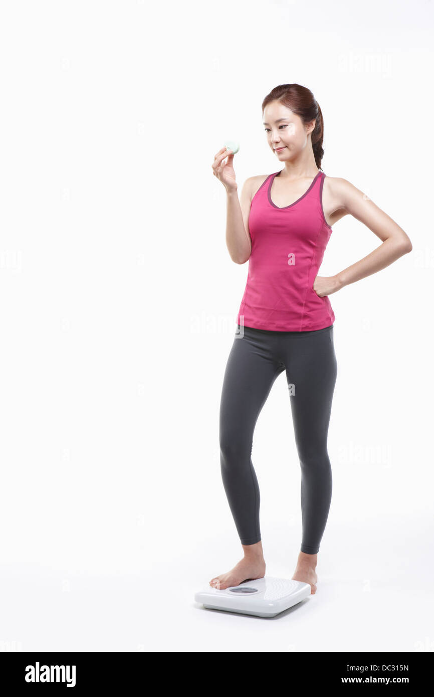 a woman standing on a weight scale Stock Photo - Alamy