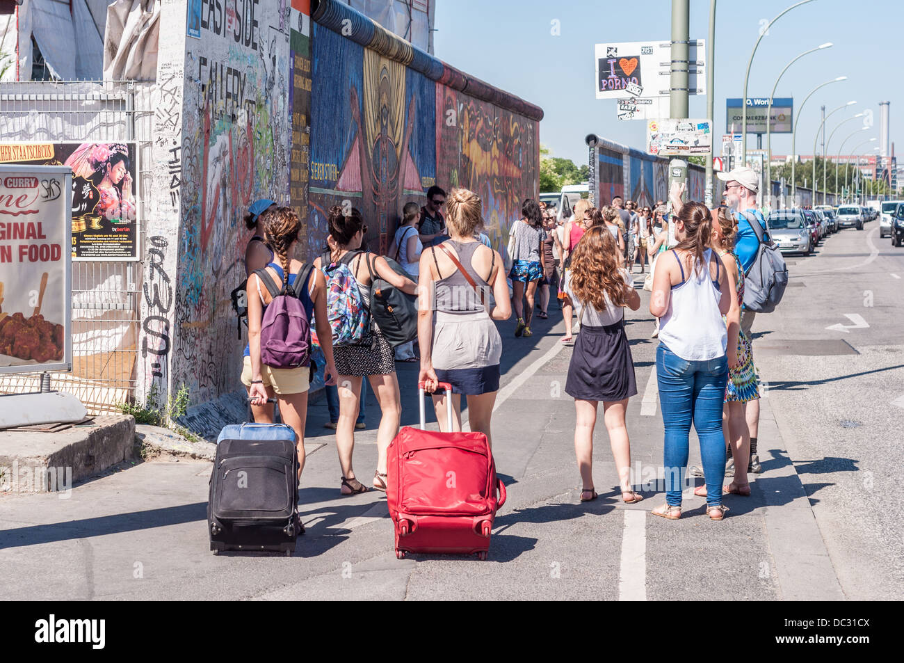 People, tourists with suitcases on wheels at the Berlin Wall, East Side ...