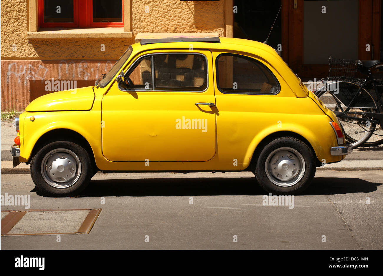 A yellow Fiat 500 is parked in a street in Berlin in July 2013. Photo ...