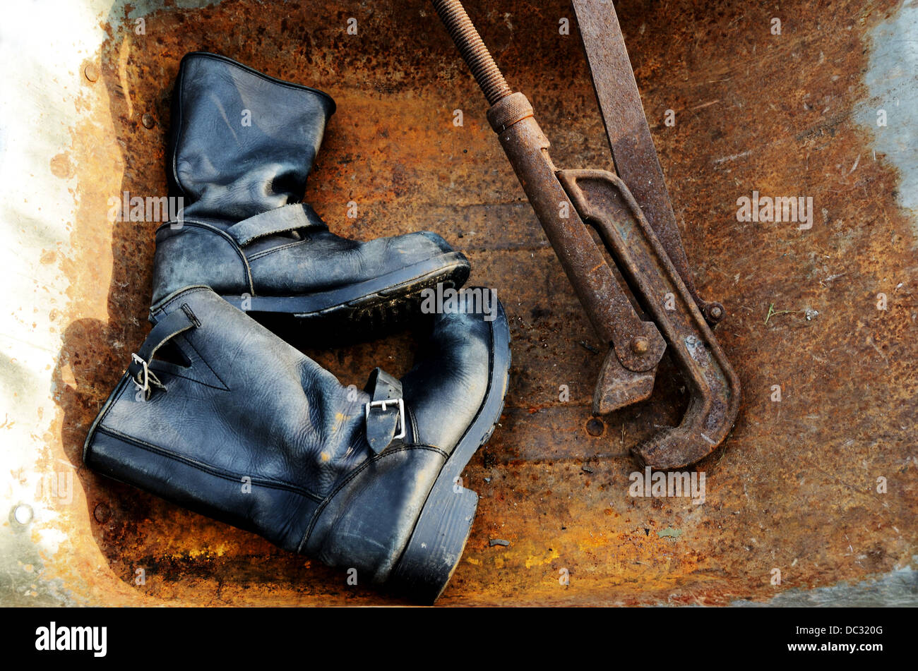 old vintage leather boots and rusty pipe wrench Stock Photo - Alamy
