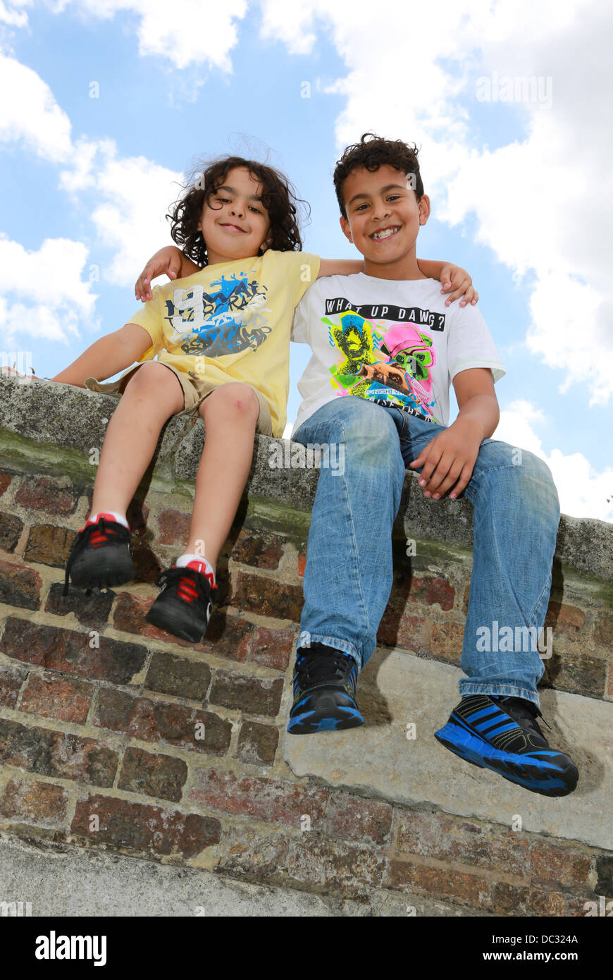 Two brothers sitting on a wall Stock Photo - Alamy
