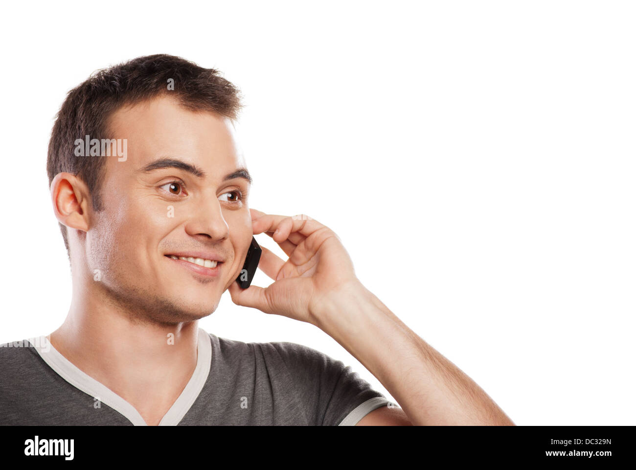 Young and healthy man answering the phone against a white background ...