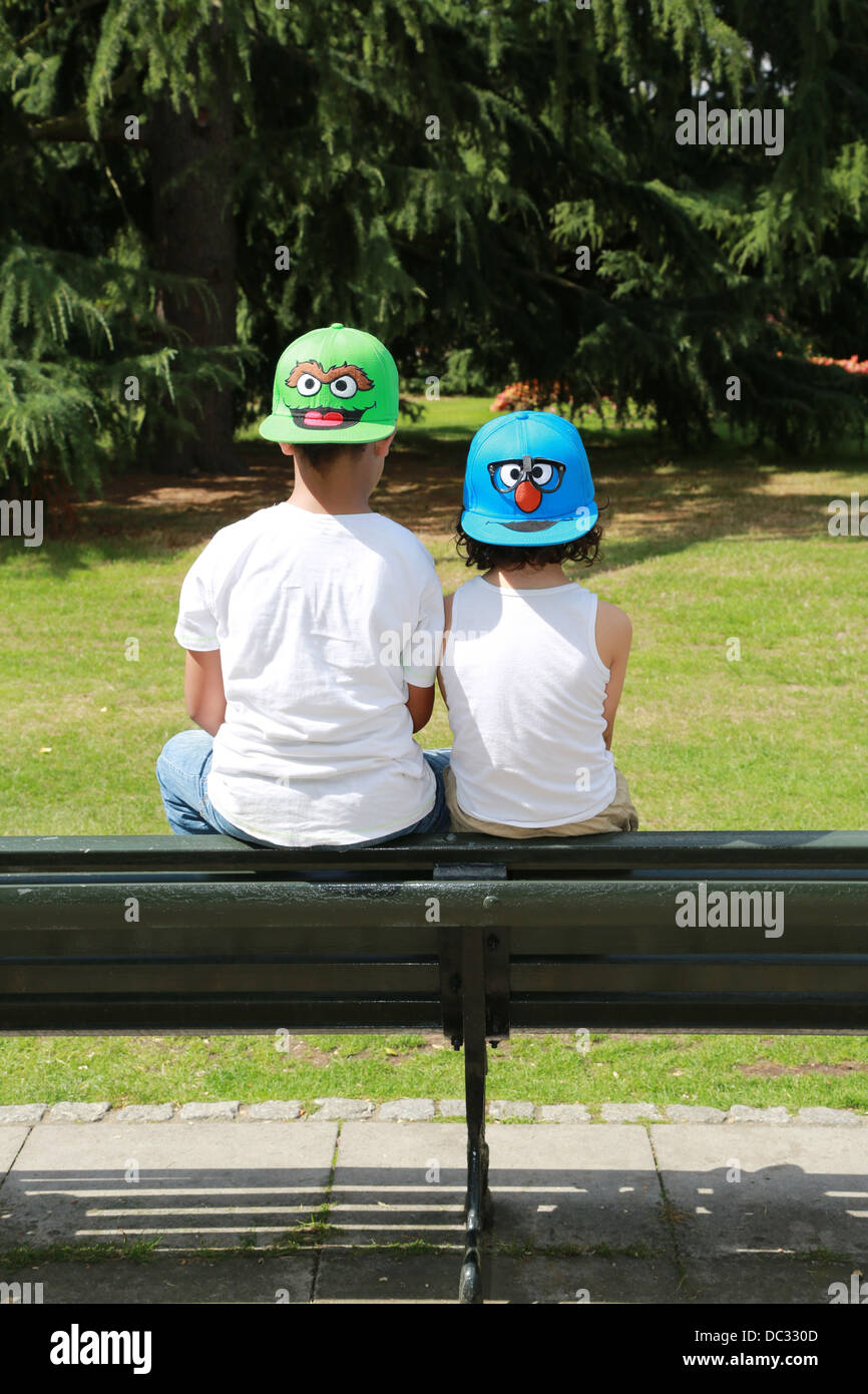 Kid's sitting on park bench Stock Photo - Alamy
