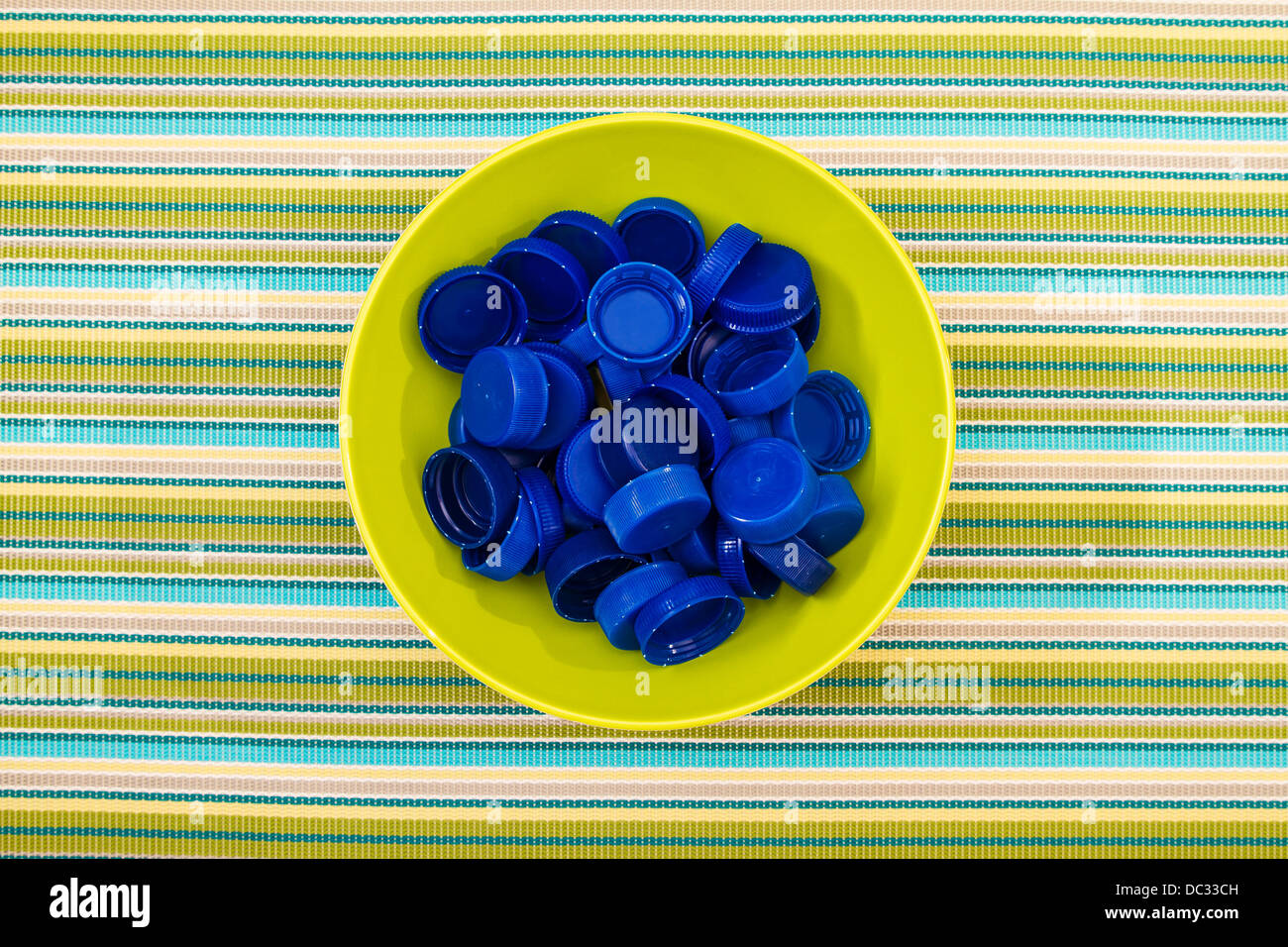 Many plastic blue lids on a green bowl Stock Photo - Alamy