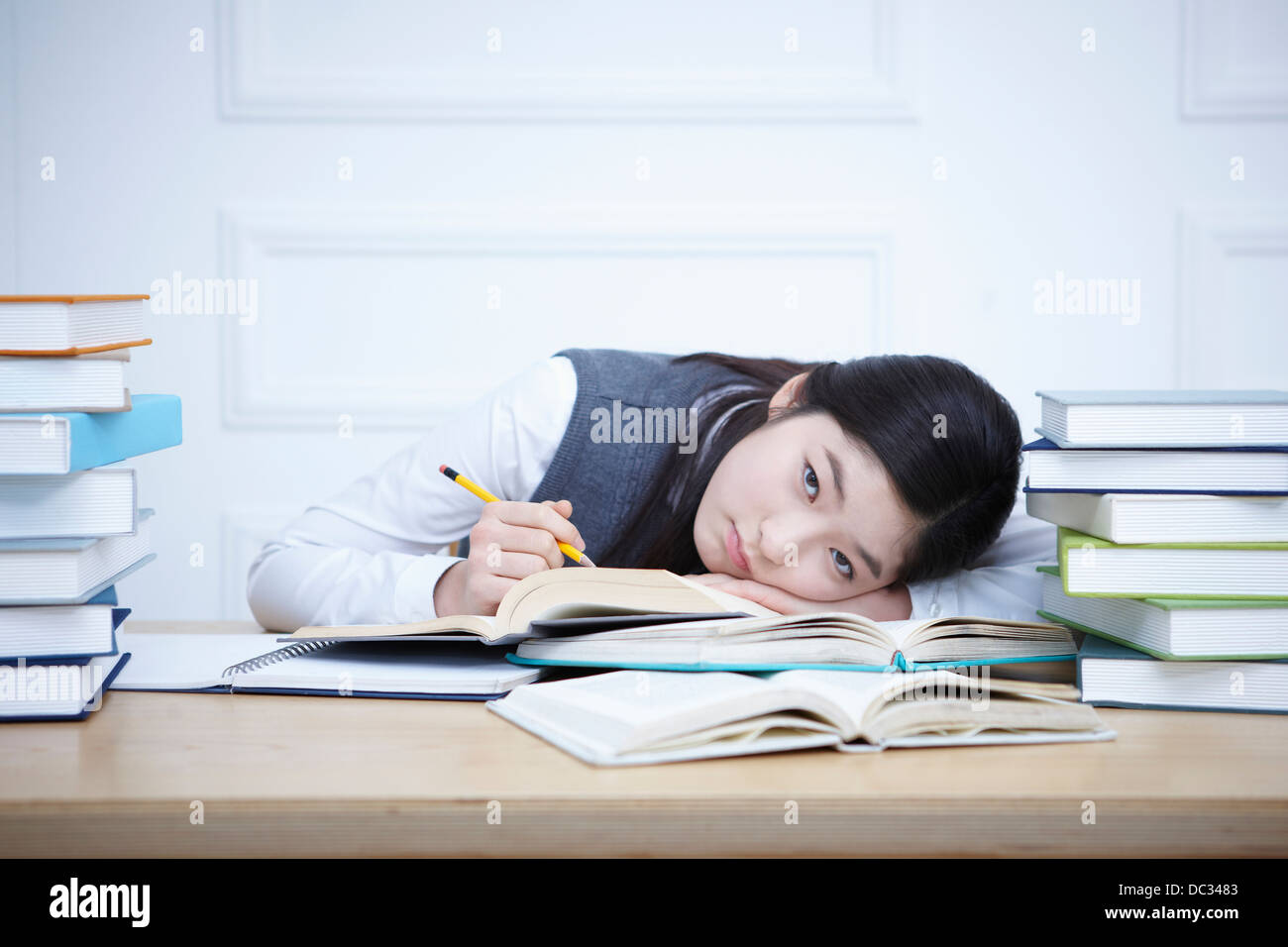 student in school uniform leaning her face on the desk Stock Photo - Alamy