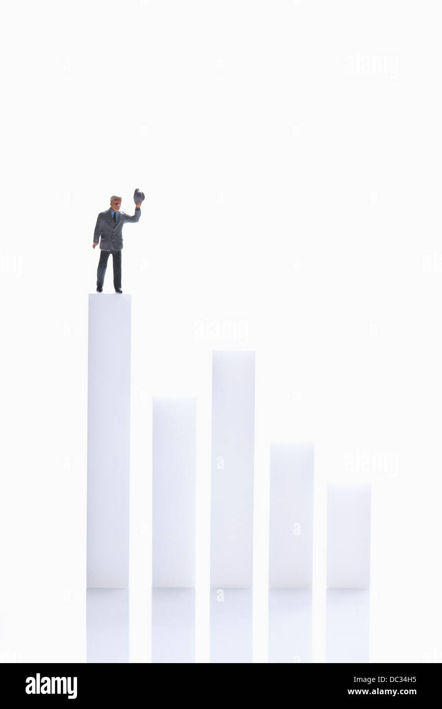 toy man standing on bar graph Stock Photo - Alamy