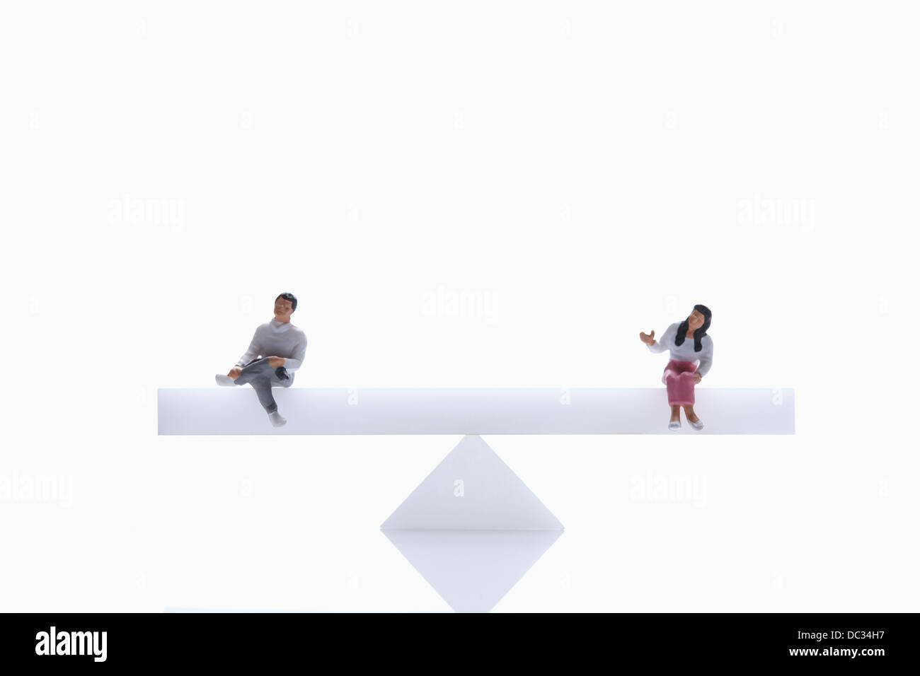 two toy people sitting on measuring scale Stock Photo - Alamy