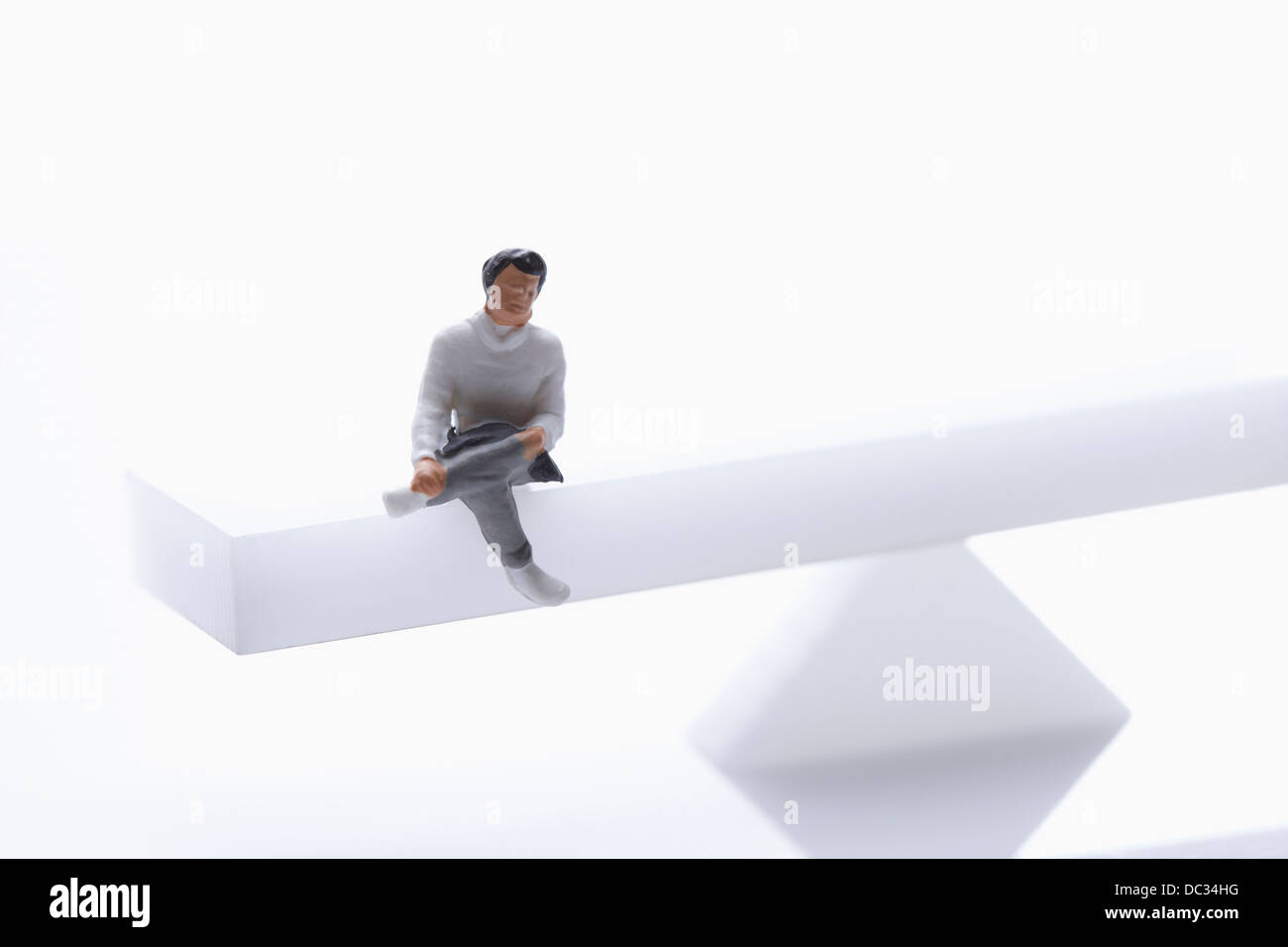 toy man sitting on measuring scale Stock Photo - Alamy