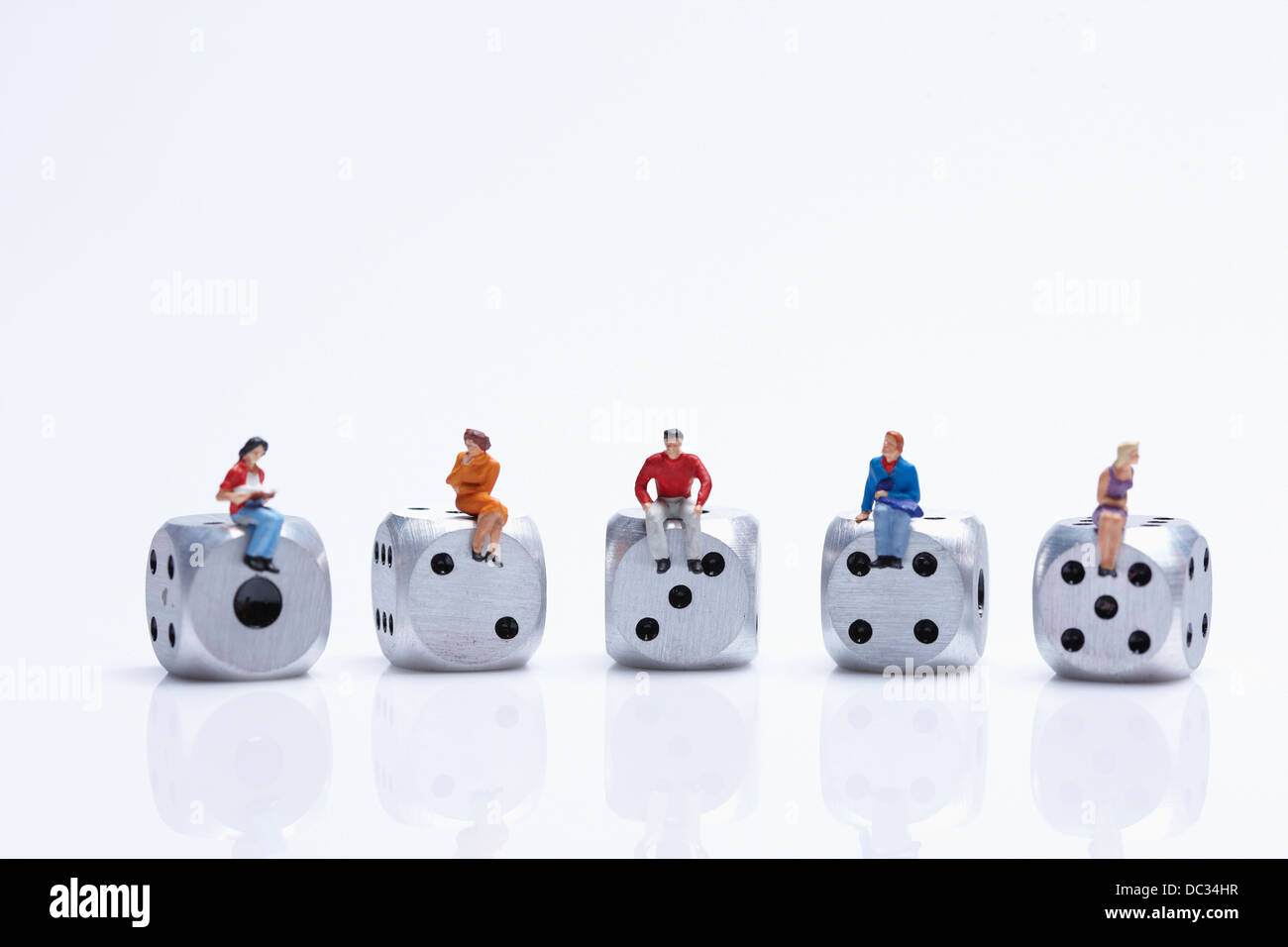 different toy people sitting on dice Stock Photo - Alamy